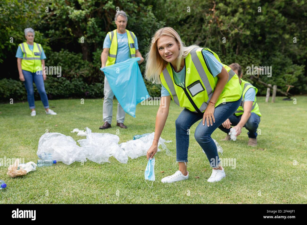 Caucasian woman picking up face mask with group of men and women ...