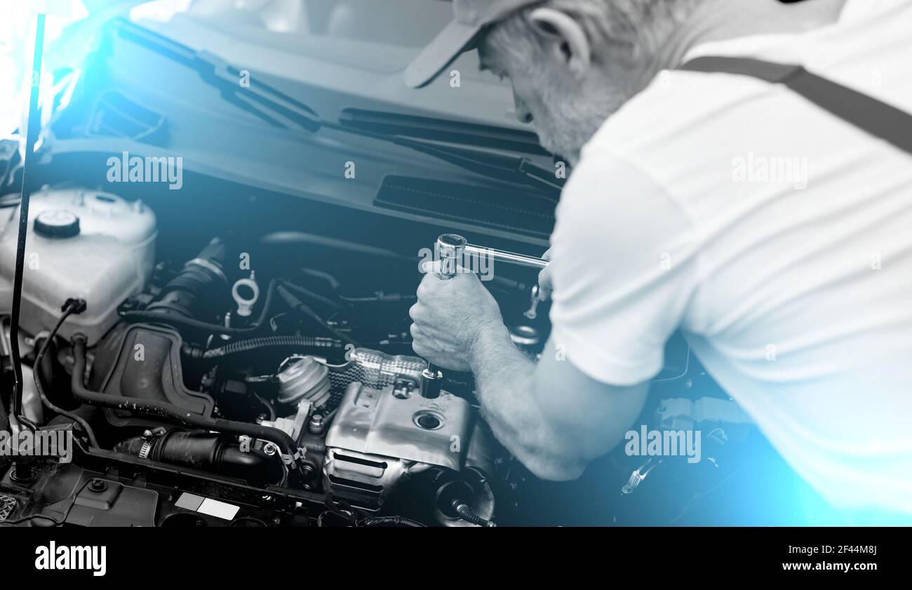 Car mechanic repairing a car engine; light effect Stock Photo - Alamy