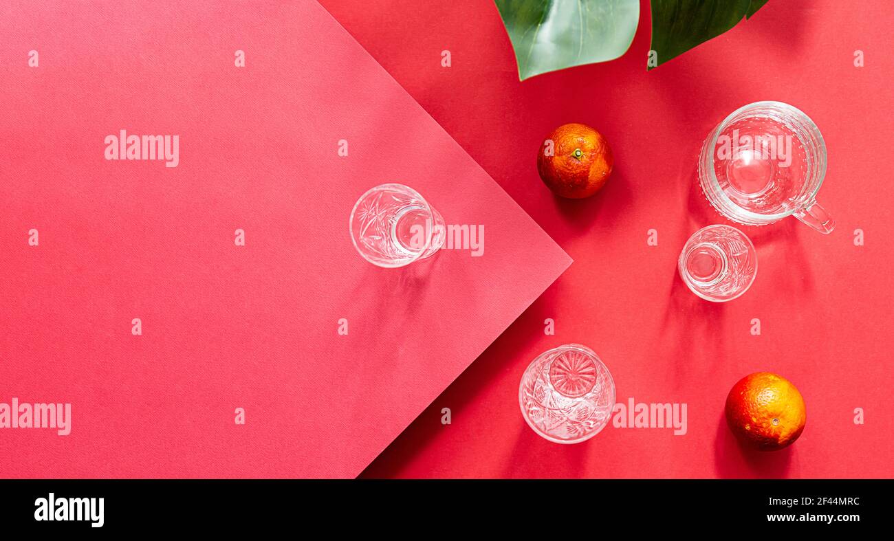 Minimalistic still life of orange fruits and glasses of water top view ...