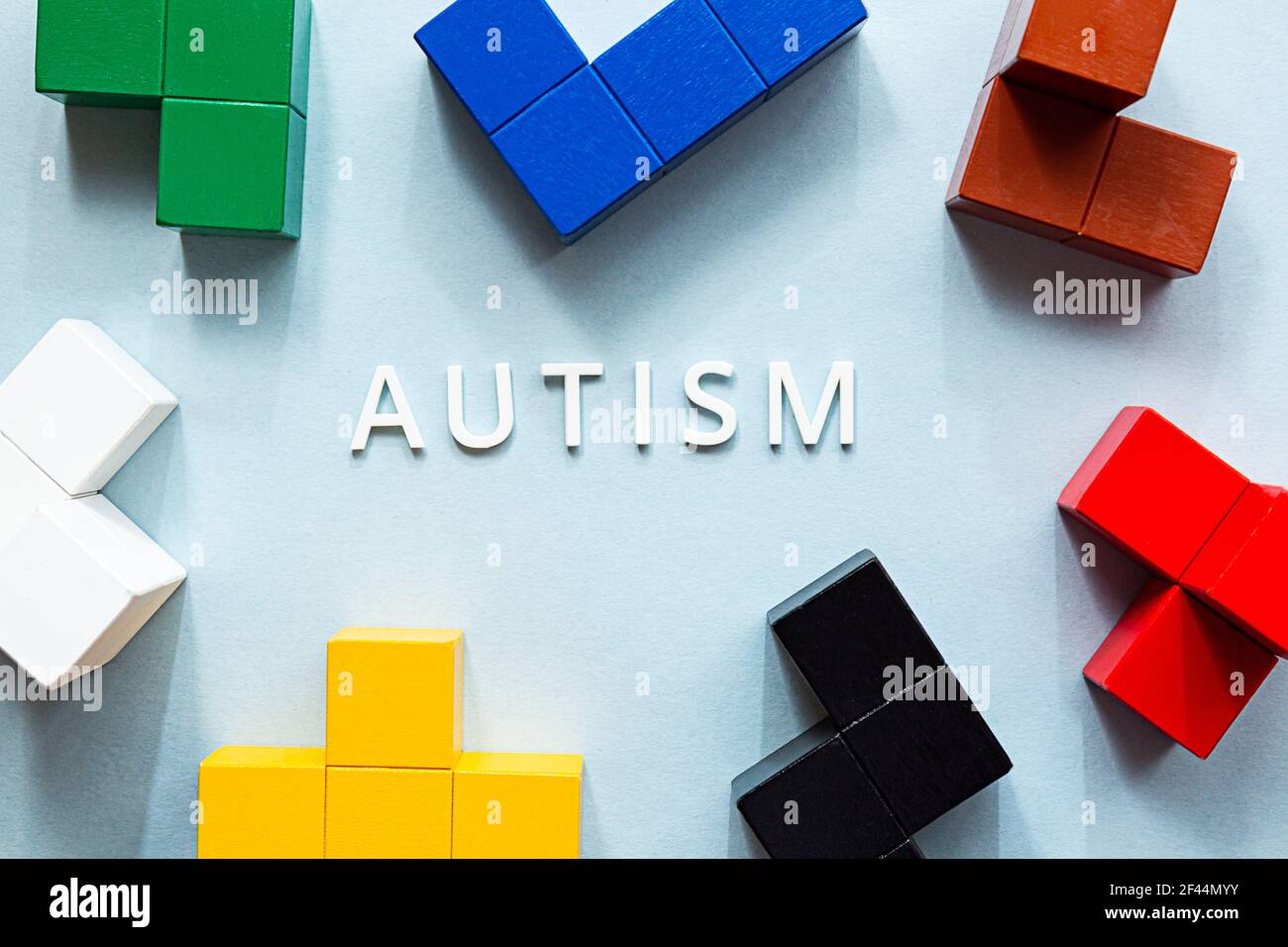 The word AUTISM on a blue background, with various colored blue cubes ...