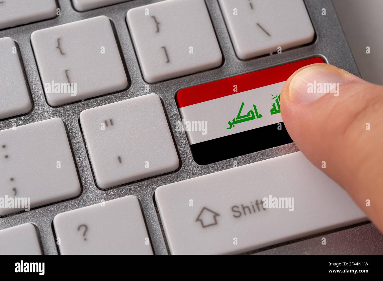 Male hand pressing keyboard button with flag of Iraq on it. Online ...