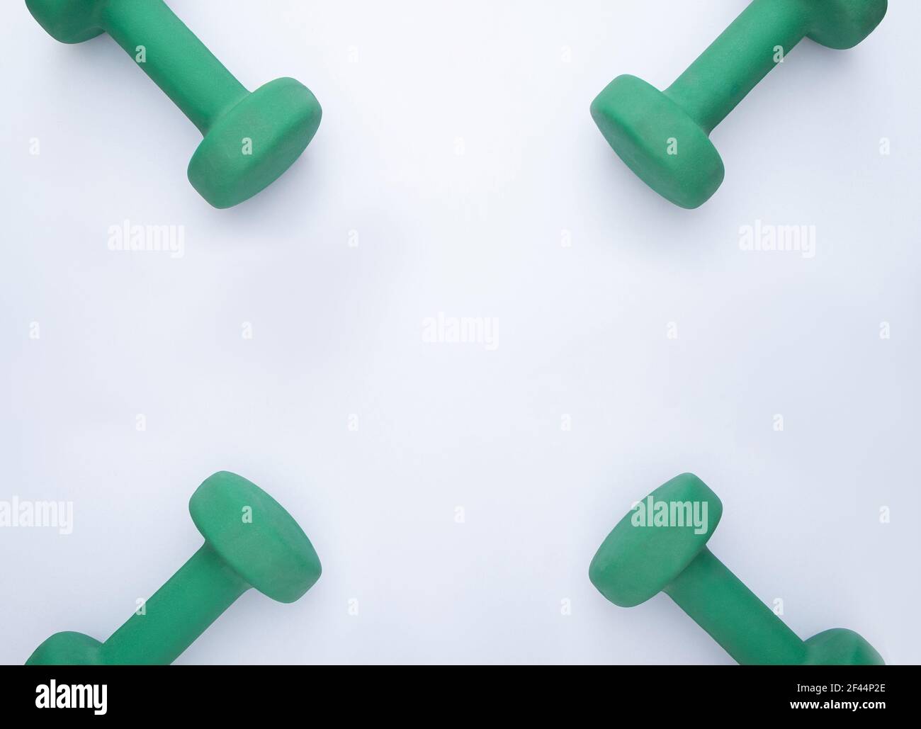 Square frame made from green exercise dumbbell weights on light ...