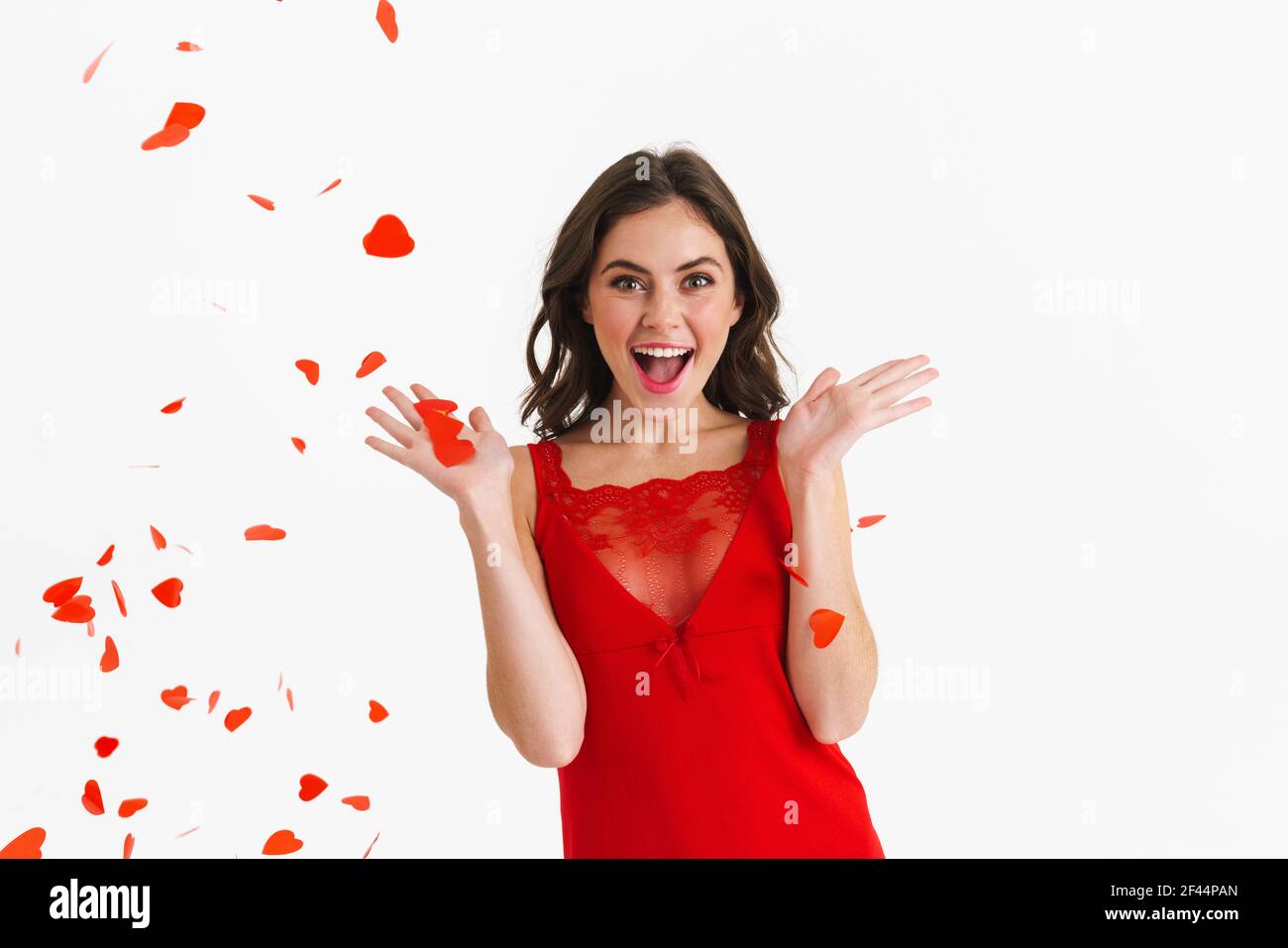Excited beautiful girl wearing red dress expressing surprise on camera ...