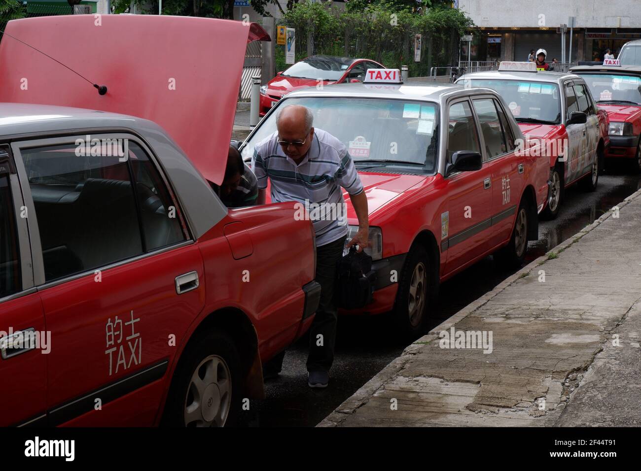 Hong Kong red taxi driver prepares for his shift work Stock Photo - Alamy