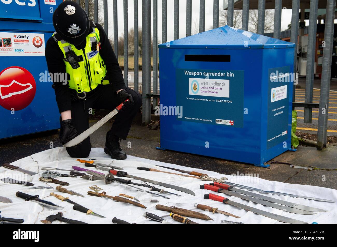 A police officer holds a machete whilst showing the knives and other ...