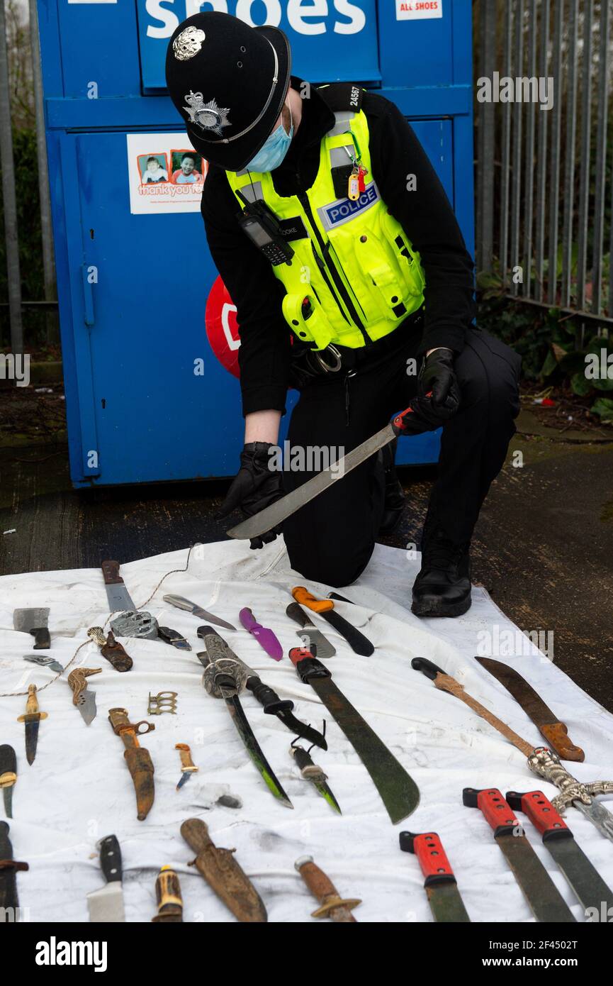 A police officer holds a machete whilst showing the knives and other ...