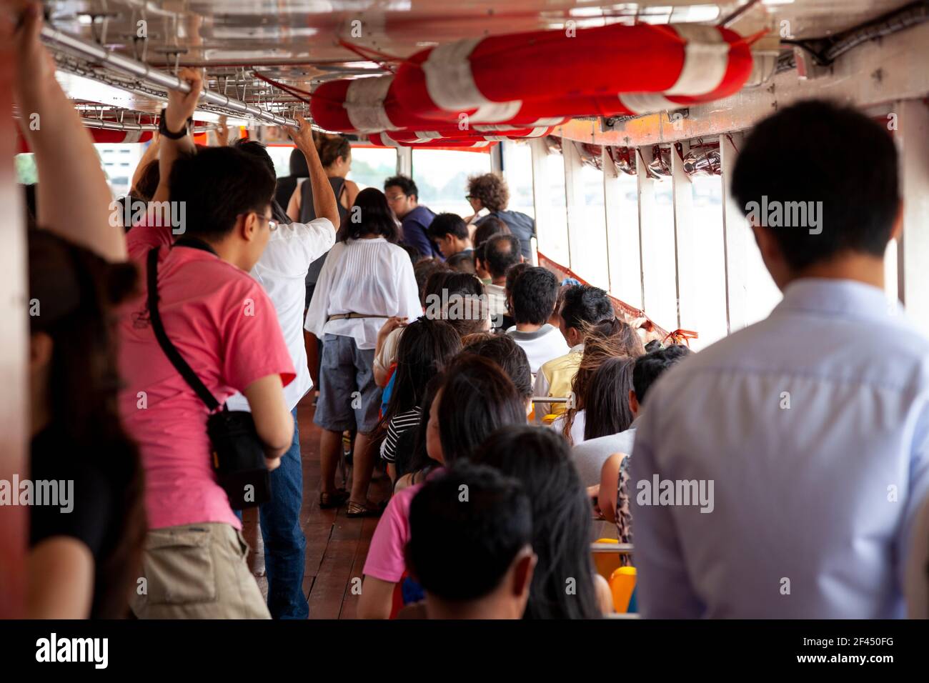 Tourists and locals crowd inside a boat along the Chao Phraya river in ...