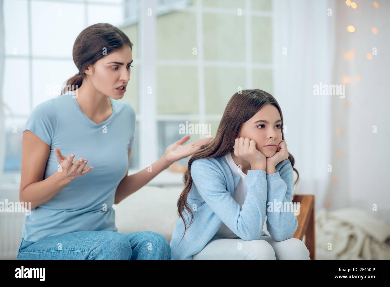 Gesturing angry mom and misunderstanding turned away daughter Stock ...