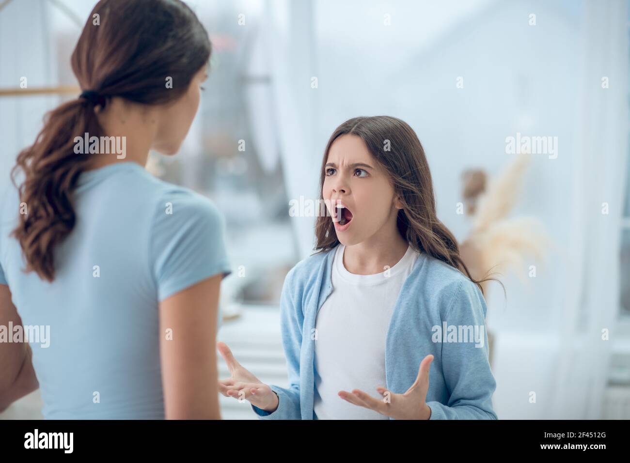 Angry screaming teen girl and listening mom Stock Photo - Alamy