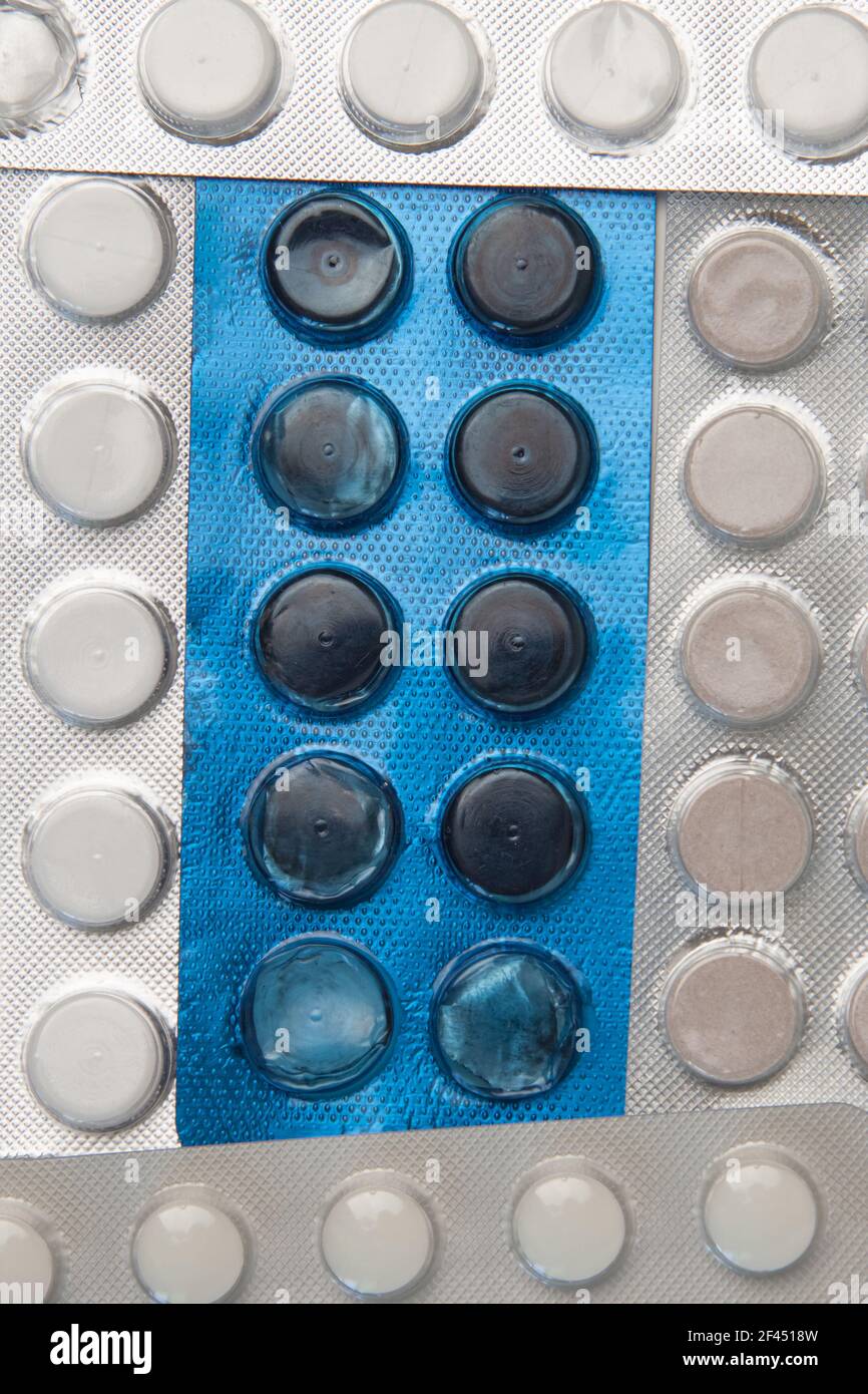 Silver and blue blister packs with round-shaped tablets. Background ...