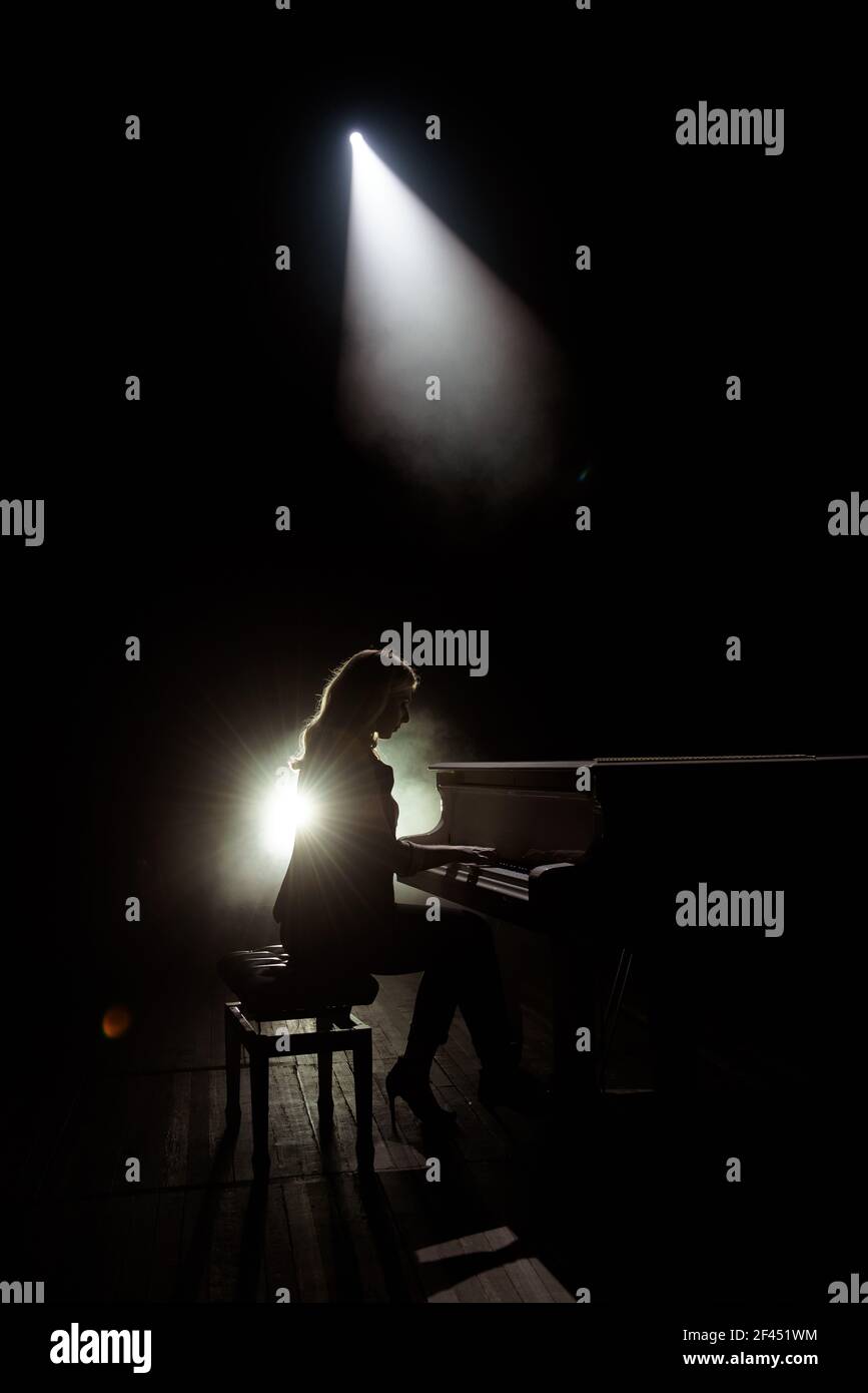Female keyboards player on stage during concert, backlight Stock Photo ...