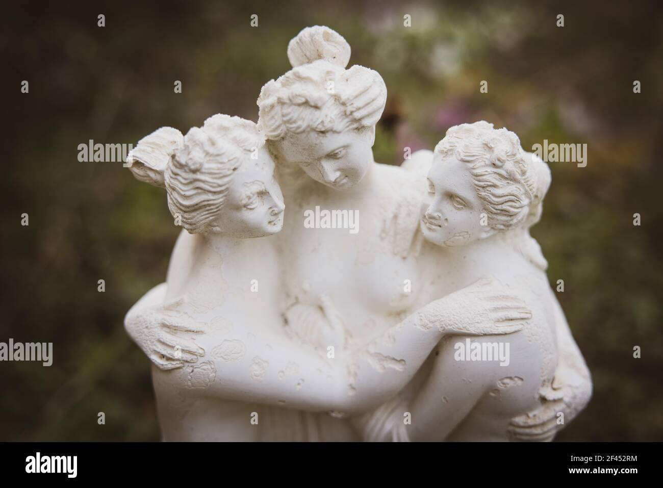 A selective focus shot of the statue of the "Three Graces" outdoors ...