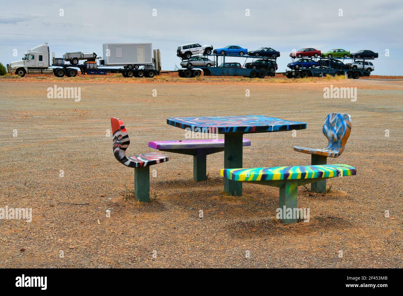Australia, colorful seating group in rest area and truck with trailers ...