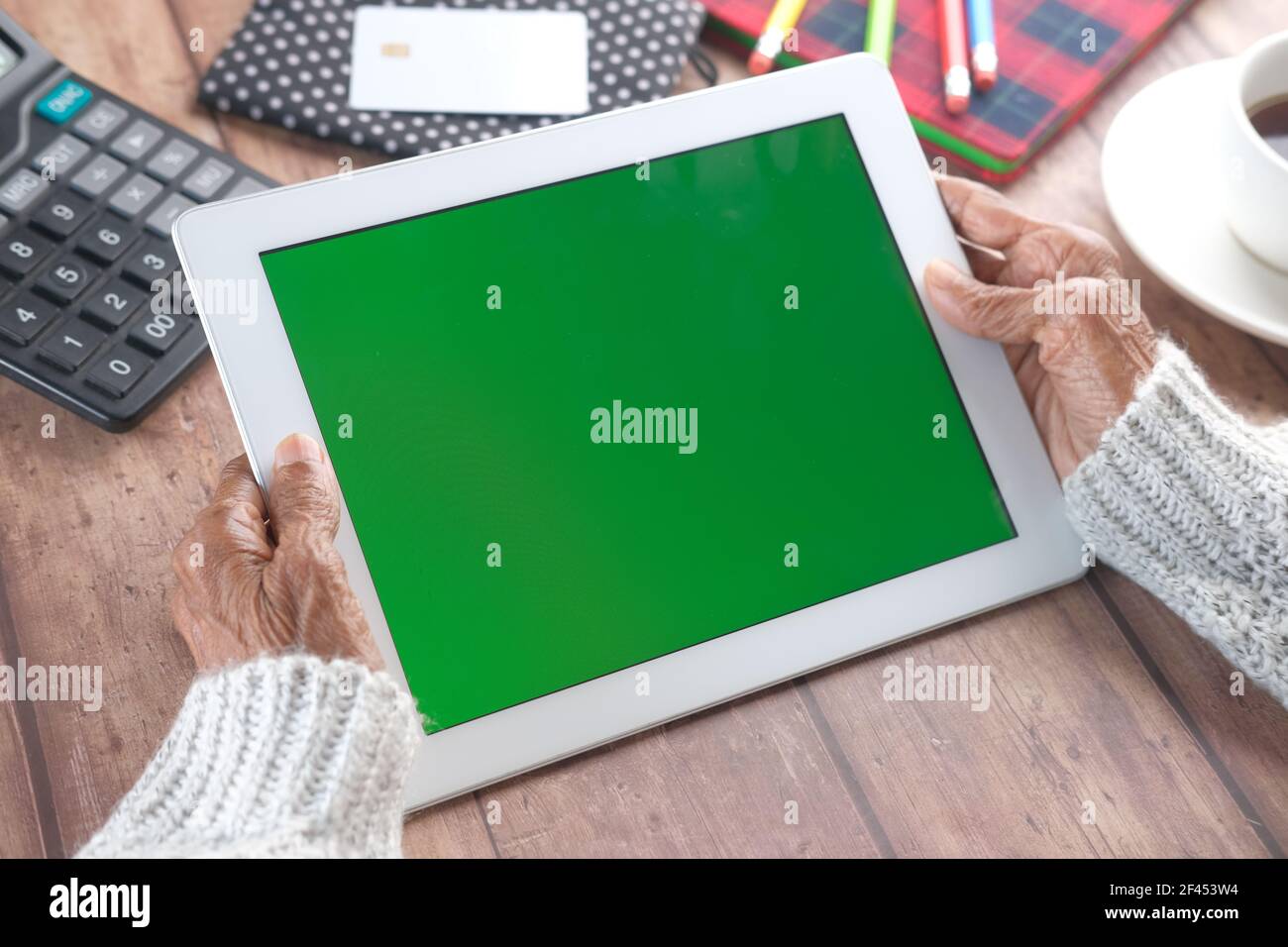 senior women holding digital tablet with green screen on table Stock ...