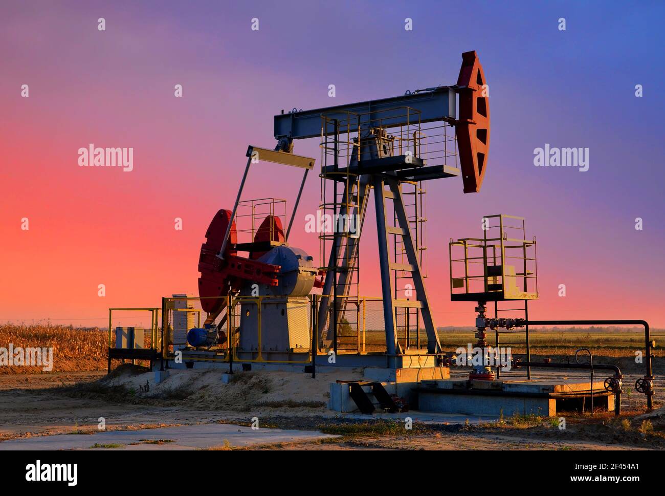 Crude oil pump jack at oilfield on atmospheric sunset backround. Fossil crude output and fuels ...