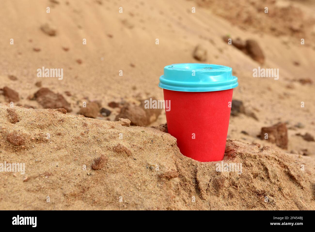 Discarded Paper coffee cup on sand at beach. Disposable coffee cup on ...