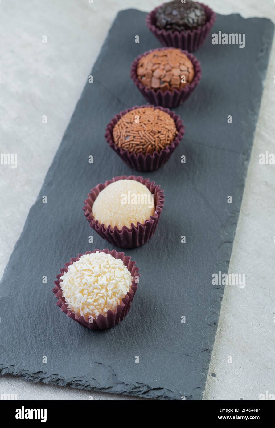 Typical brazilian brigadeiros, various flavors over stone board, low ...