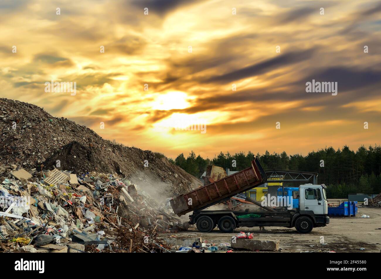 Garbage truck unloads construction waste from container at the landfill ...