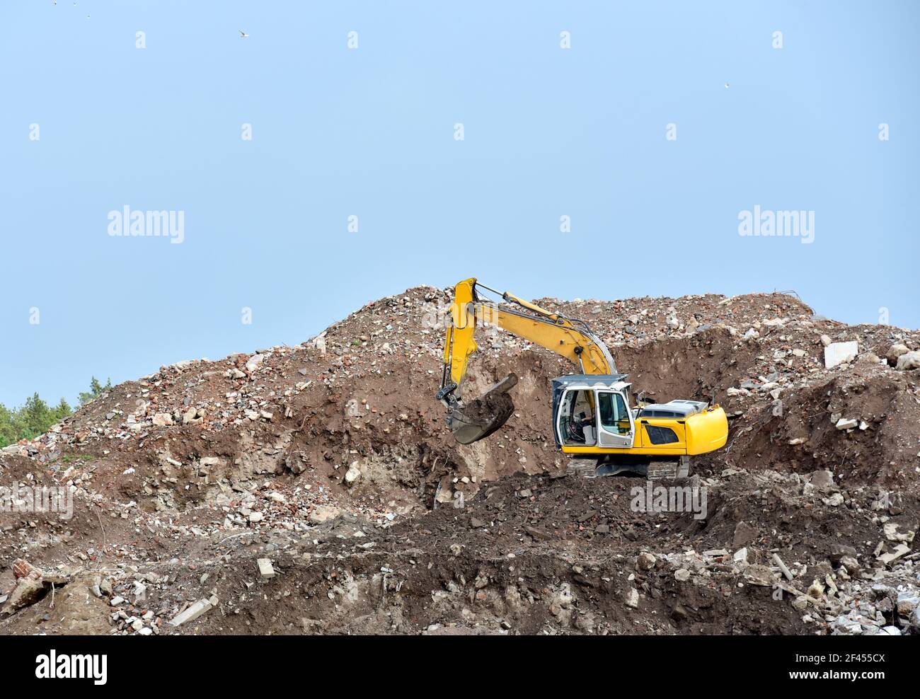 Recycling concrete and construction waste from demolition. Excavator at ...