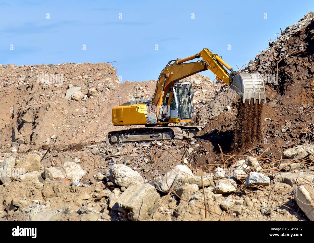 Recycling concrete and construction waste from demolition. Excavator at ...