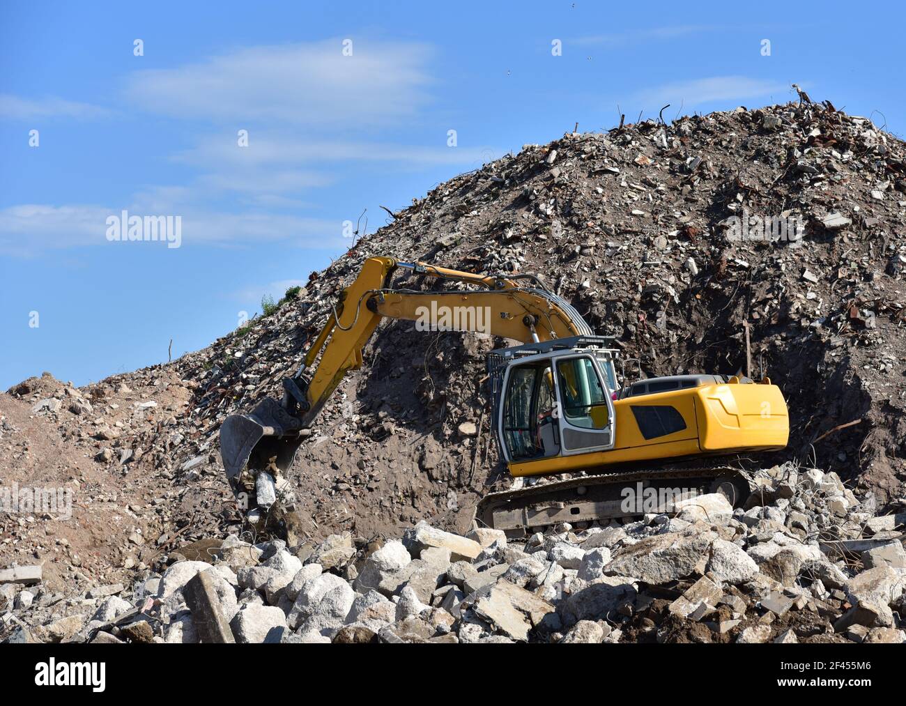 Recycling concrete and construction waste from demolition. Excavator at ...