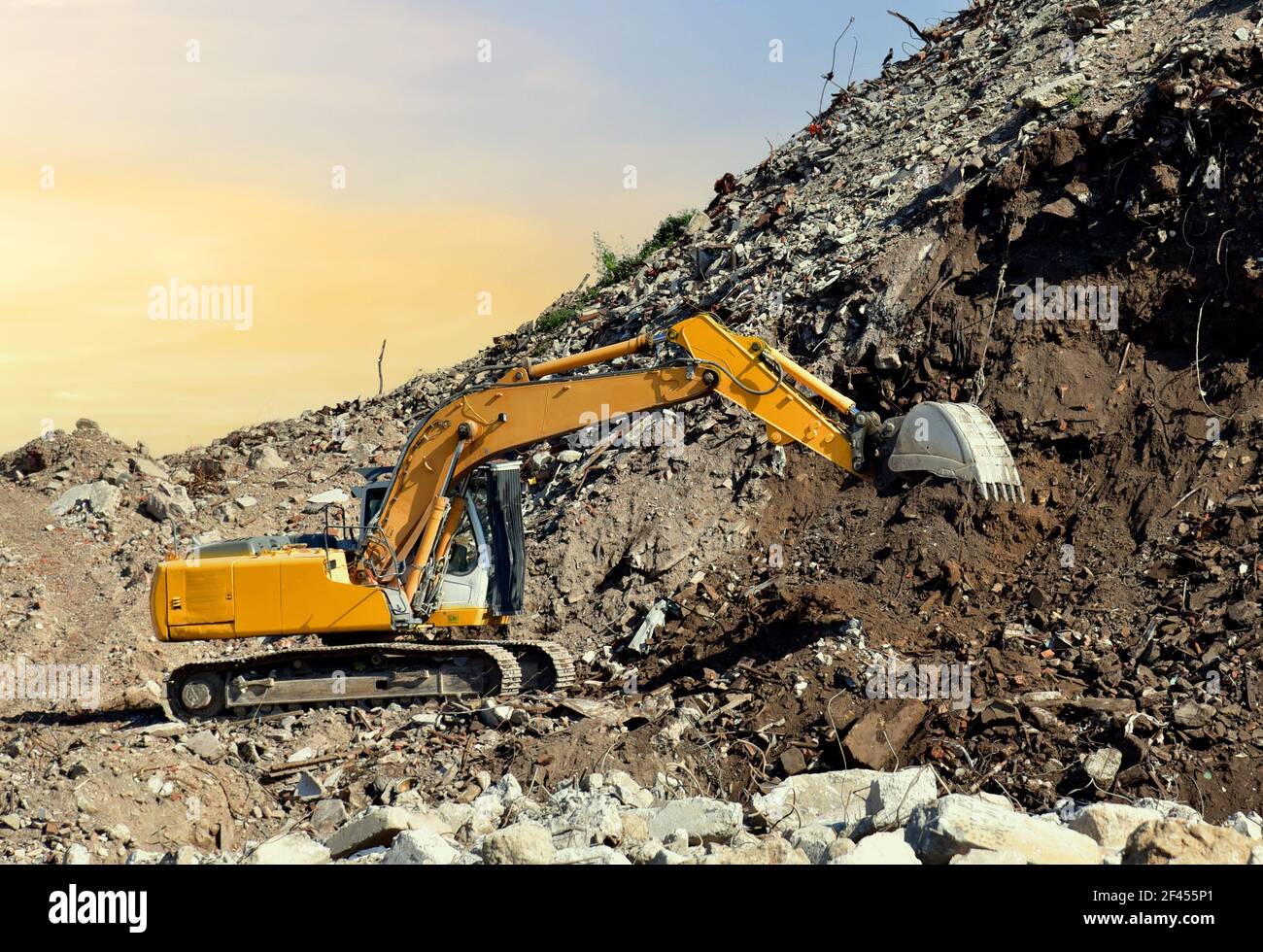 Recycling concrete and construction waste from demolition. Excavator at ...