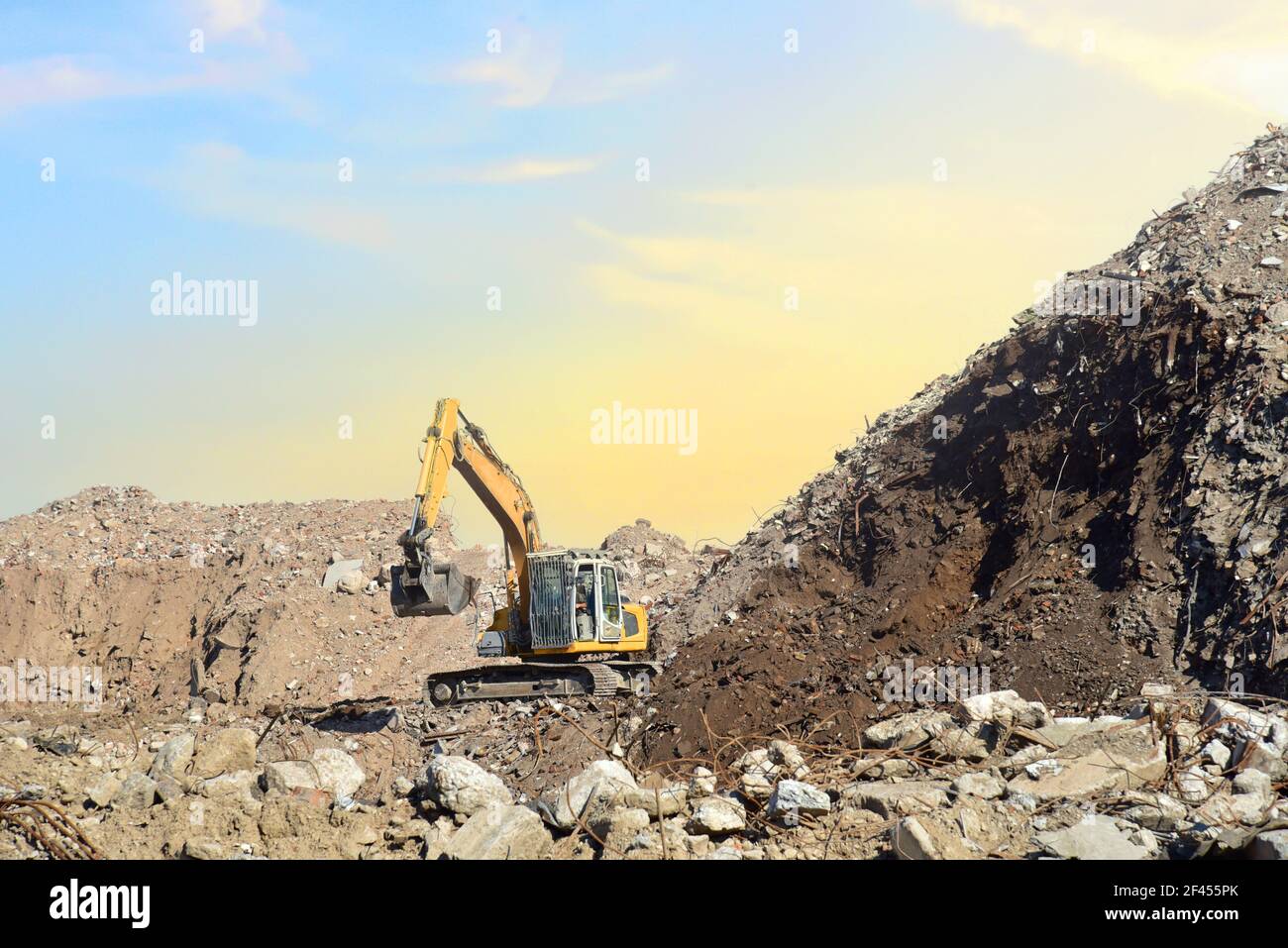 Recycling concrete and construction waste from demolition. Excavator at ...