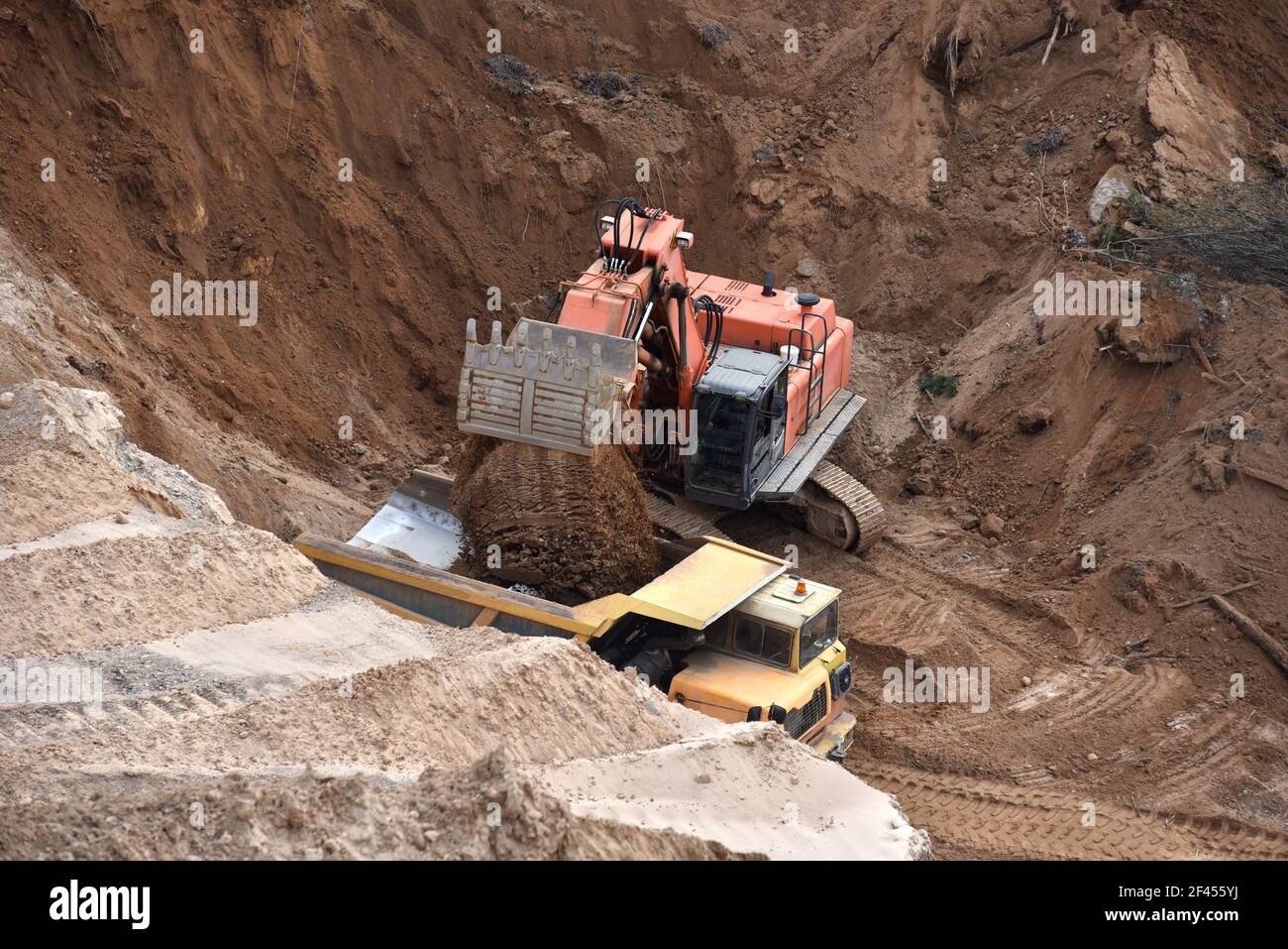 Excavator load the sand to the heavy mining truck in the open-pit ...