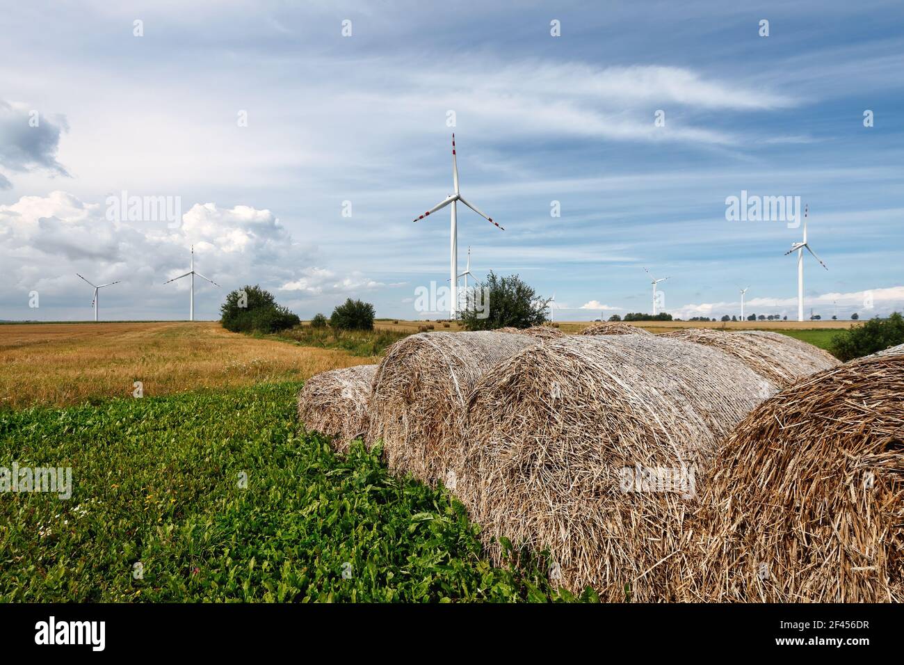 Wind turbines farm and straw bales after harvest Stock Photo - Alamy