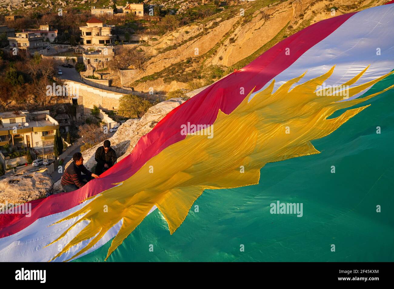 Kurds place a flag of Kurdistan over one of the mountains in the Old ...