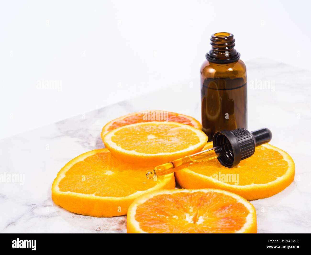 Vitamin C serum bottle with dropper on white marble background Stock ...