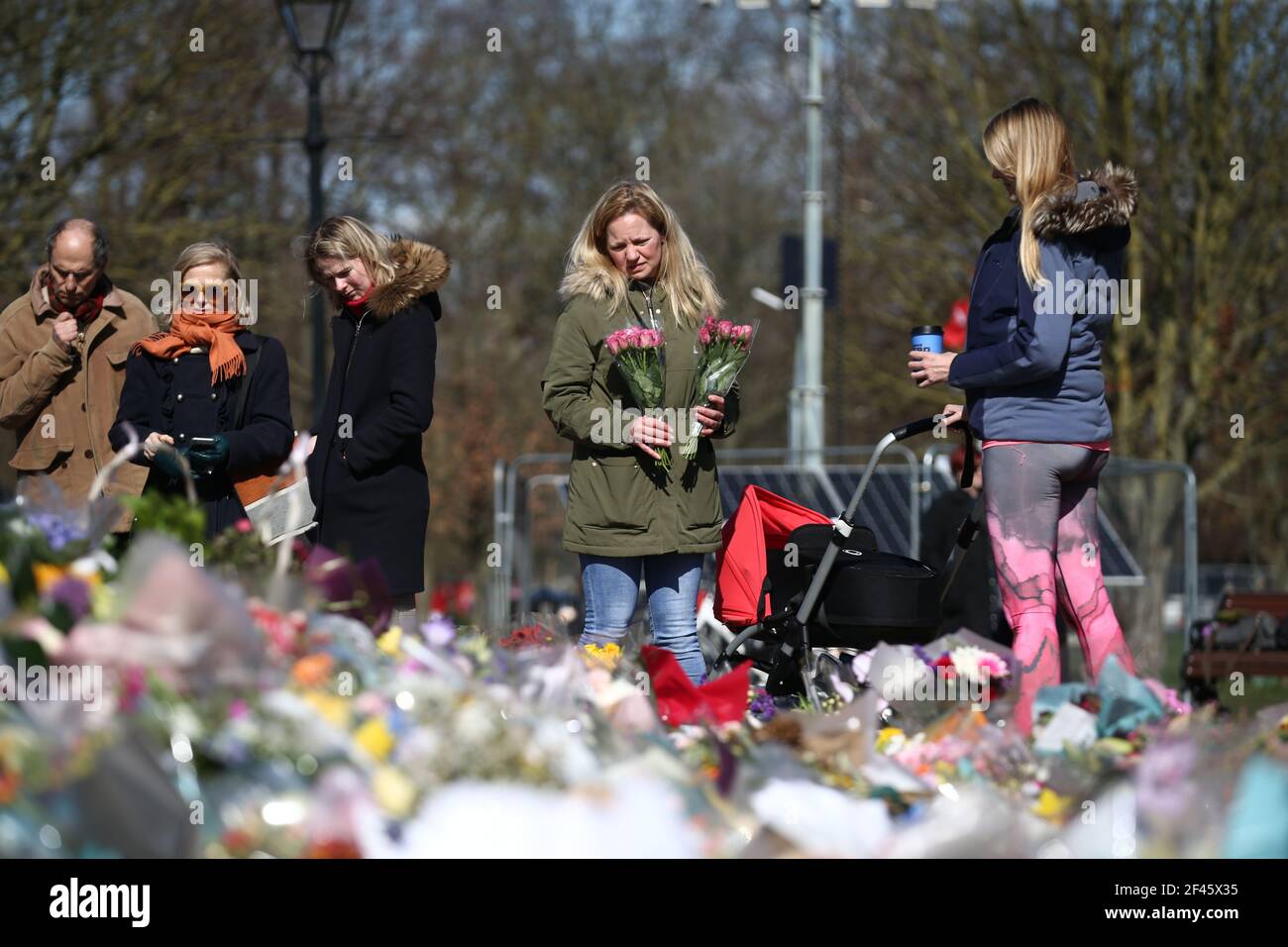 A woman arrives to lay floral tributes at the bandstand in Clapham ...