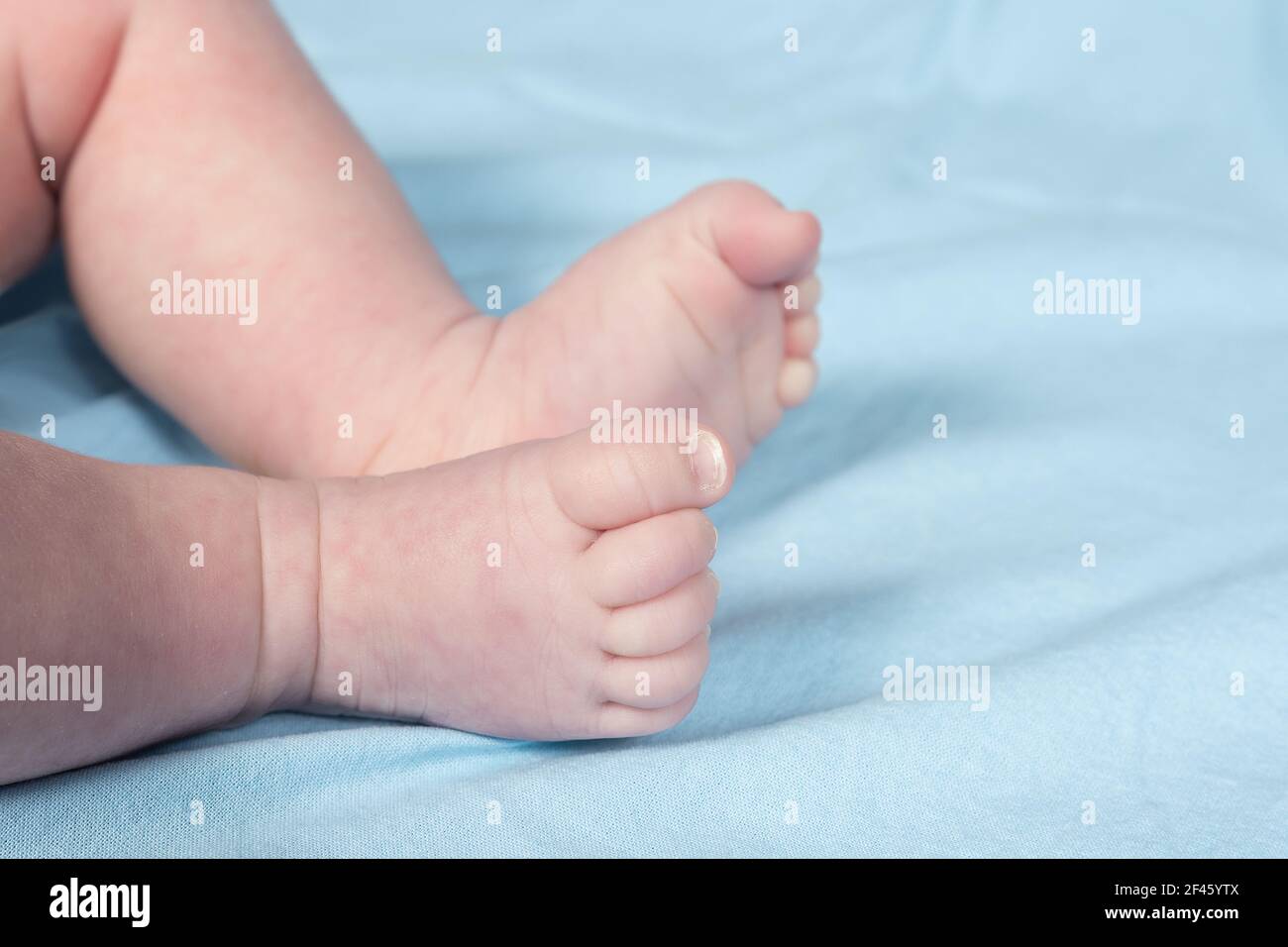 Close up view of newborn baby legs on a bed Stock Photo - Alamy