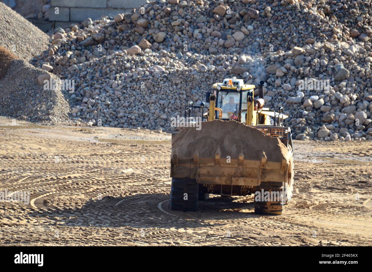 Front-end loader working in open pit. Earth-moving heavy equipment for ...