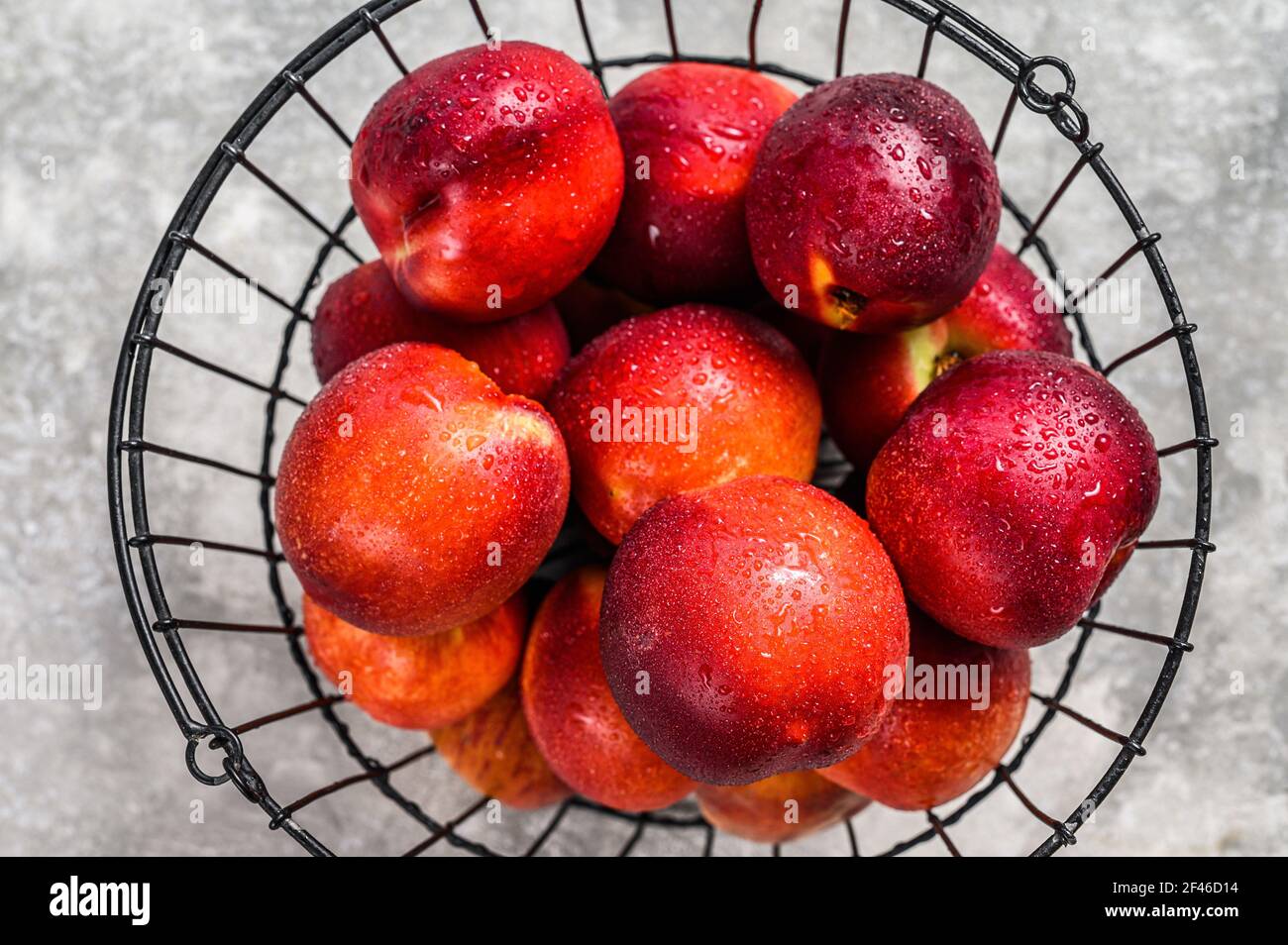 Fresh red nectarines in a steel basket. Gray background. Top view Stock ...