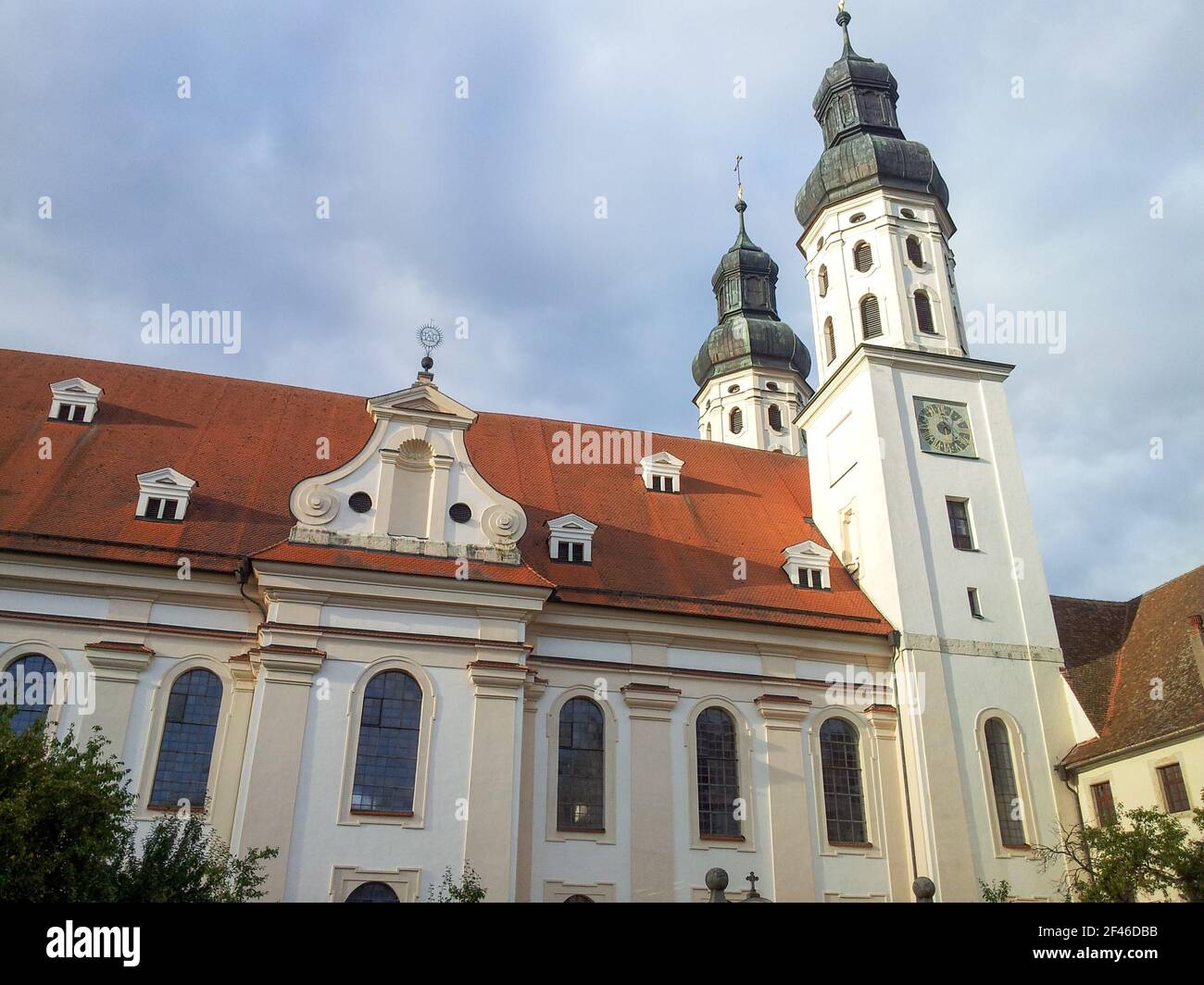 Monastery Obermarchtal sideways in summer twilight. The garden in front ...