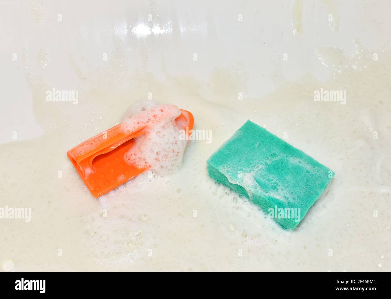 Sponge with washing brus and detergent during cleaning bathroom or ...