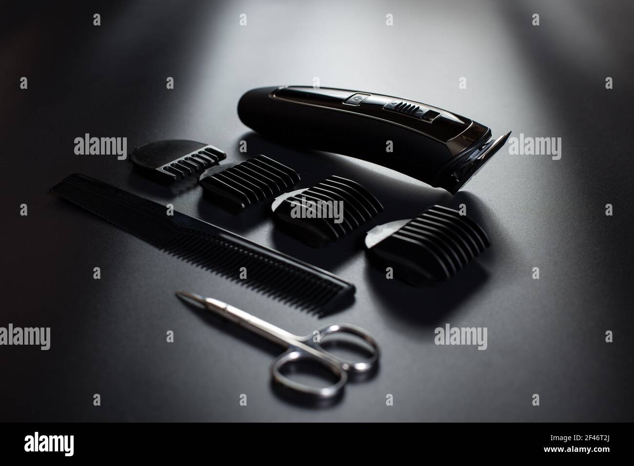 Black wireless shaving machine with attachments, close up, on black ...