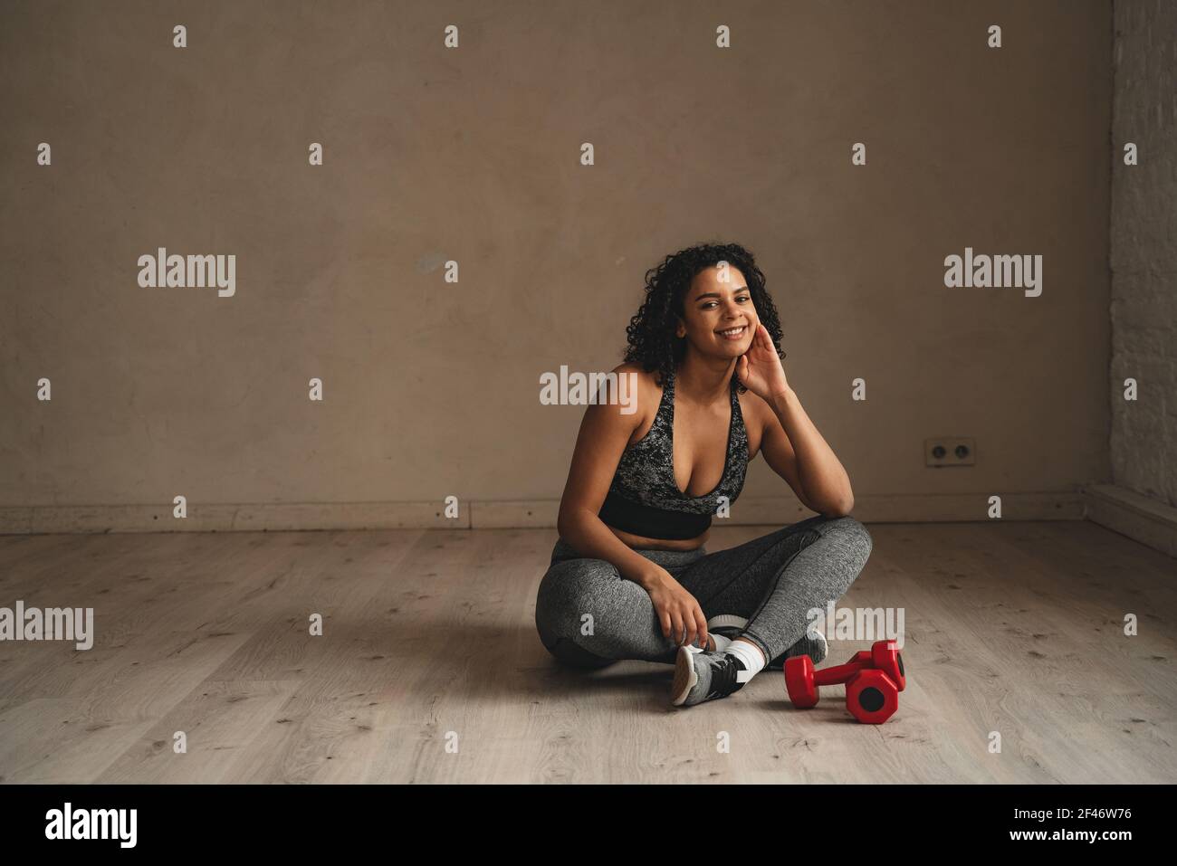 Woman relaxing after workout with dumbbells at health club. Sporty ...