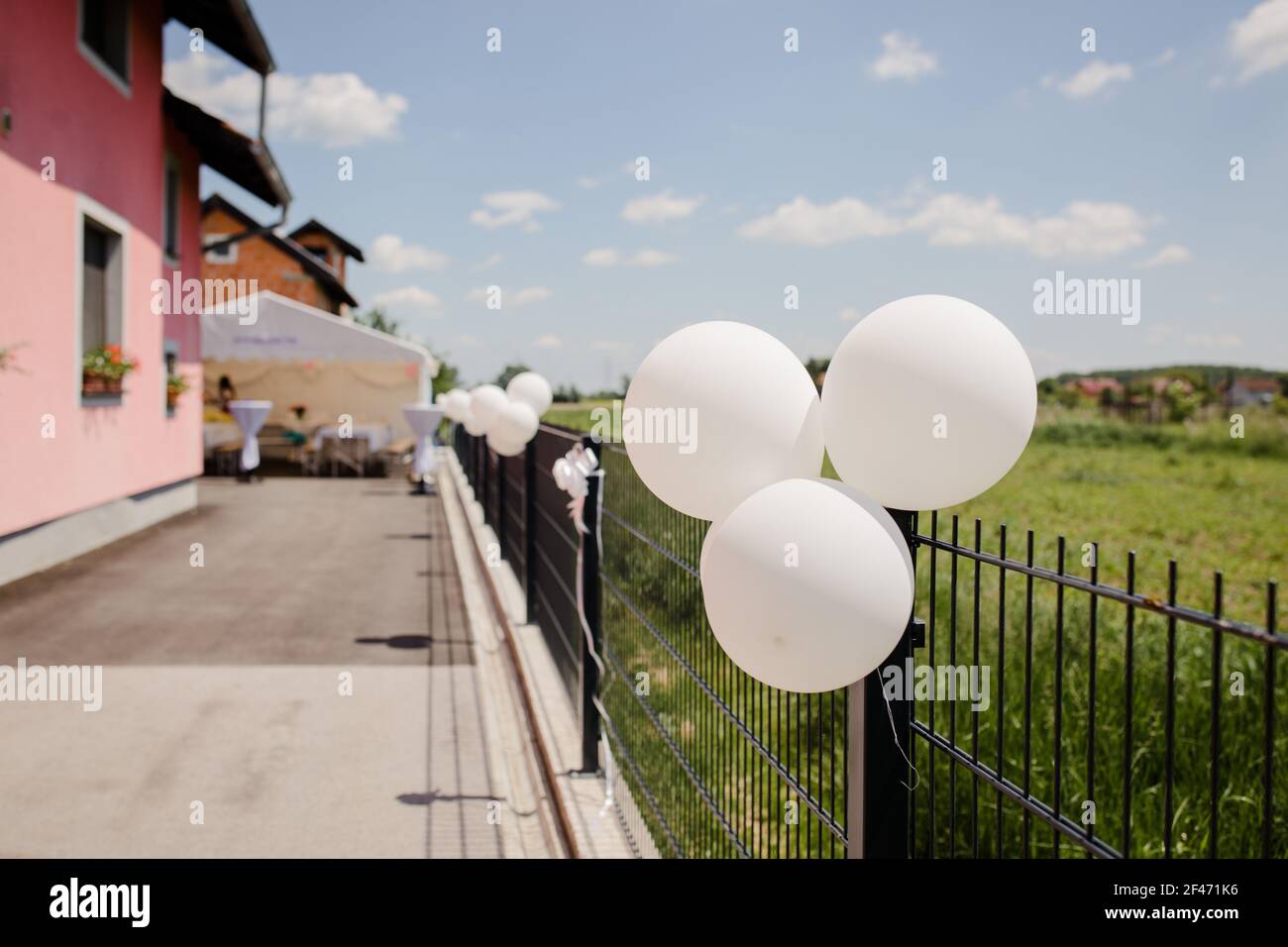 White decorations on the metal fence; decorated wedding party venue ...
