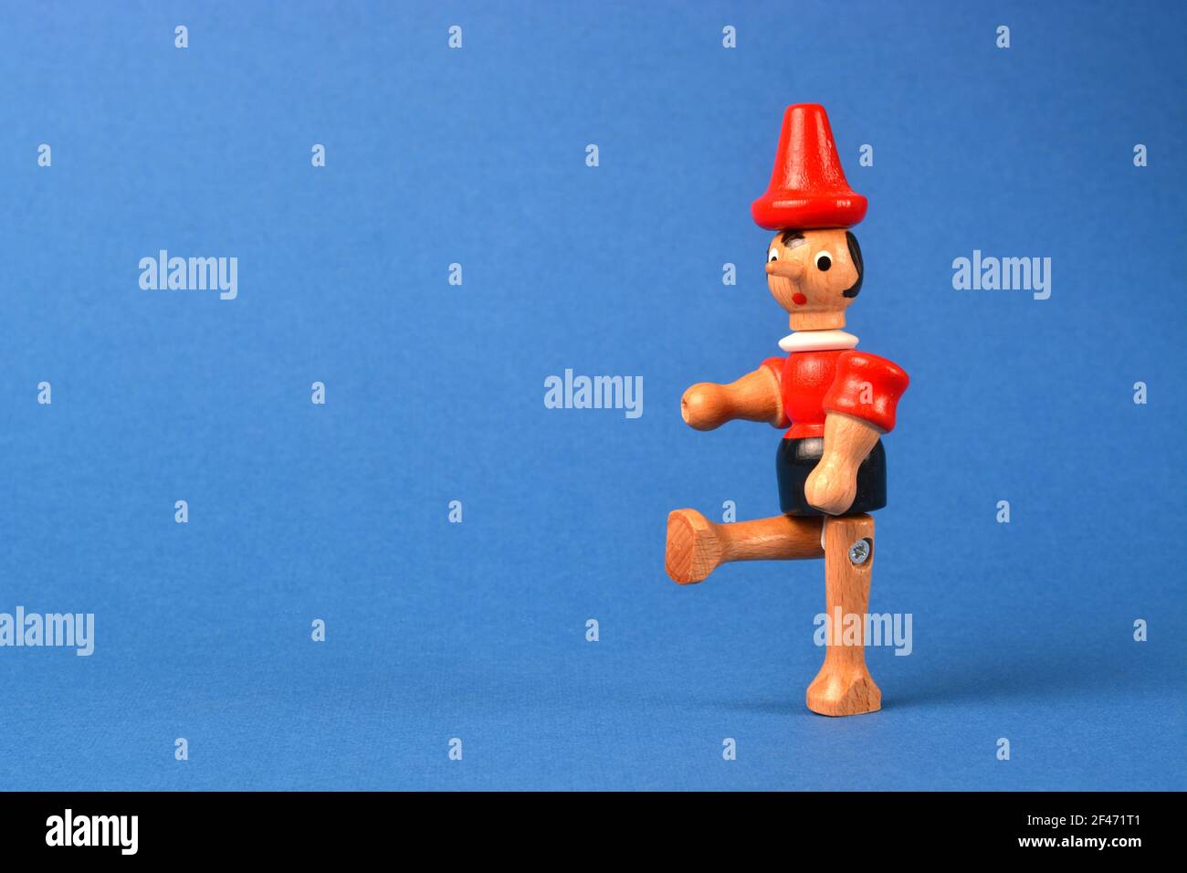 Wooden puppet depicting Pinocchio walking on a blue background Stock ...