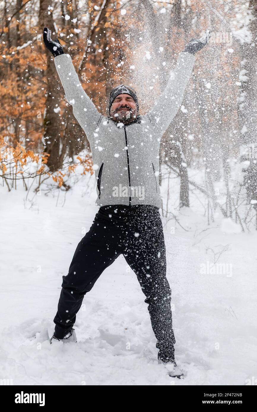 Man throws snowballs in the snowy forest Stock Photo - Alamy
