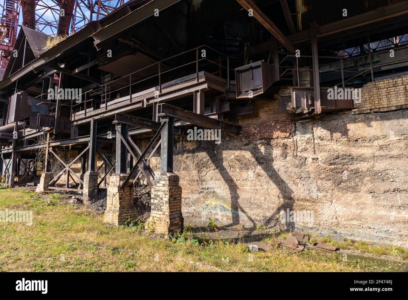 Abandoned industrial site, concrete and brick wall, outriggers of steel ...