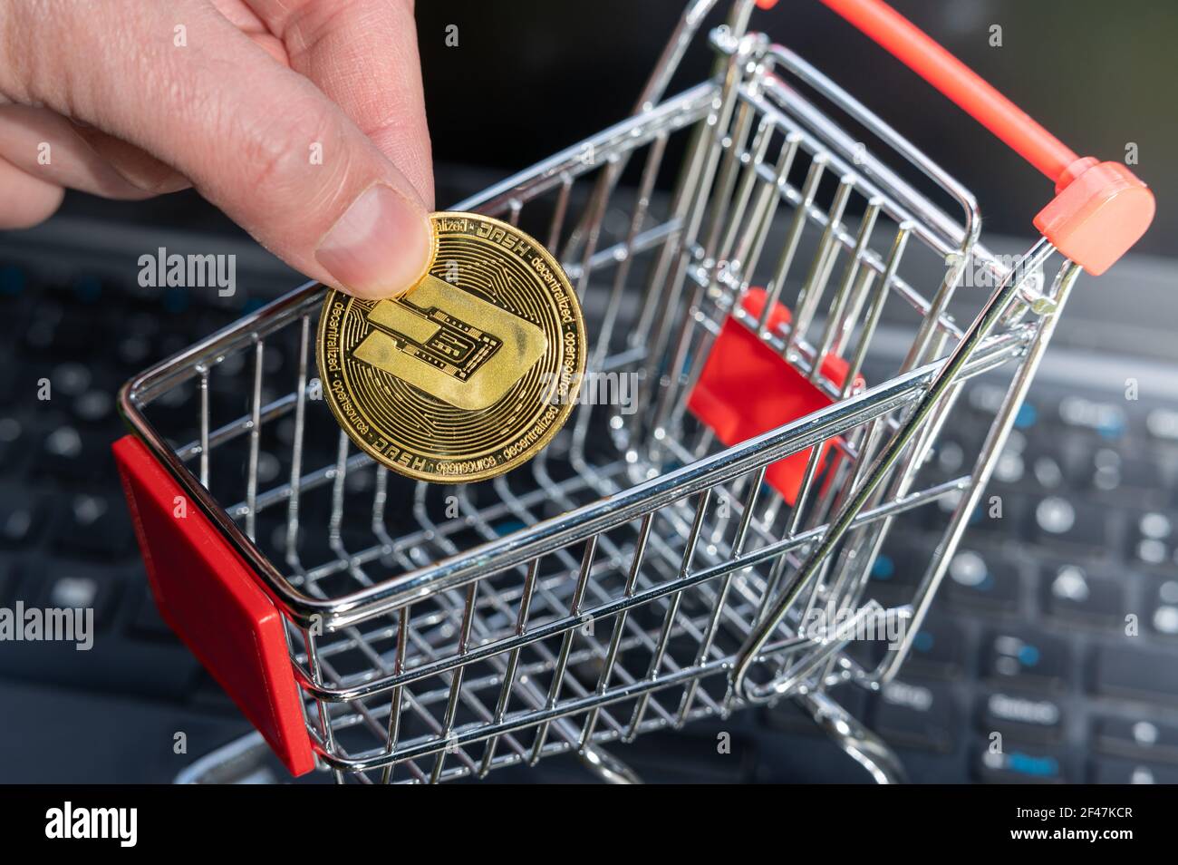 Symbol for buying Dash. Hand puts a Dash coin in a miniature shopping ...