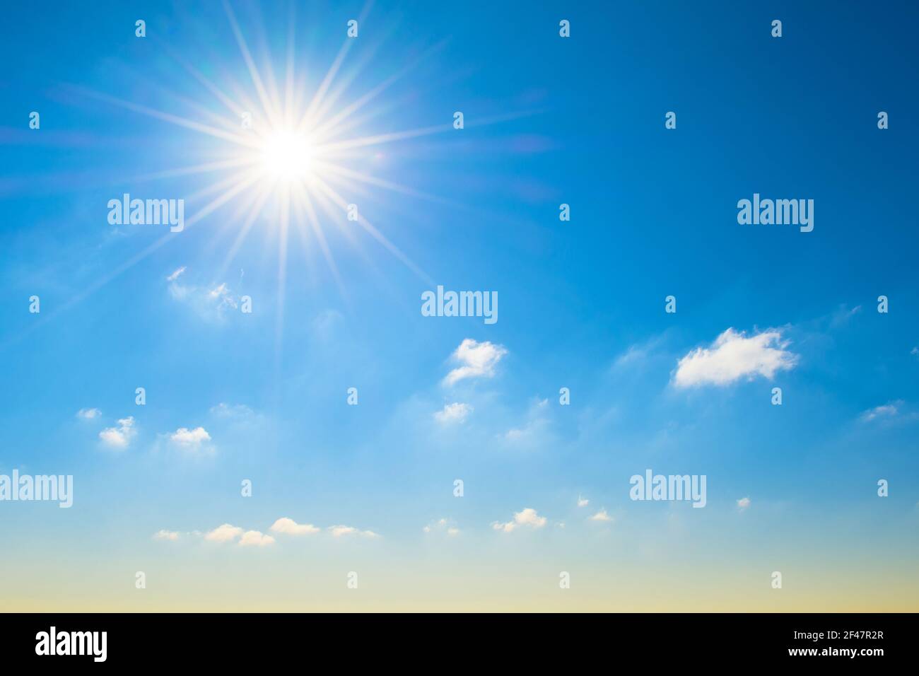 Sun with bright rays in the blue sky with white light clouds, at the ...