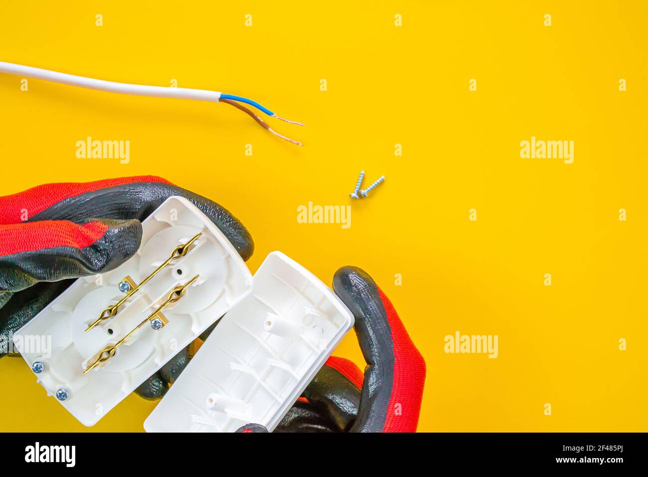 Electrician peeling off insulation from wires - closeup on hands and ...