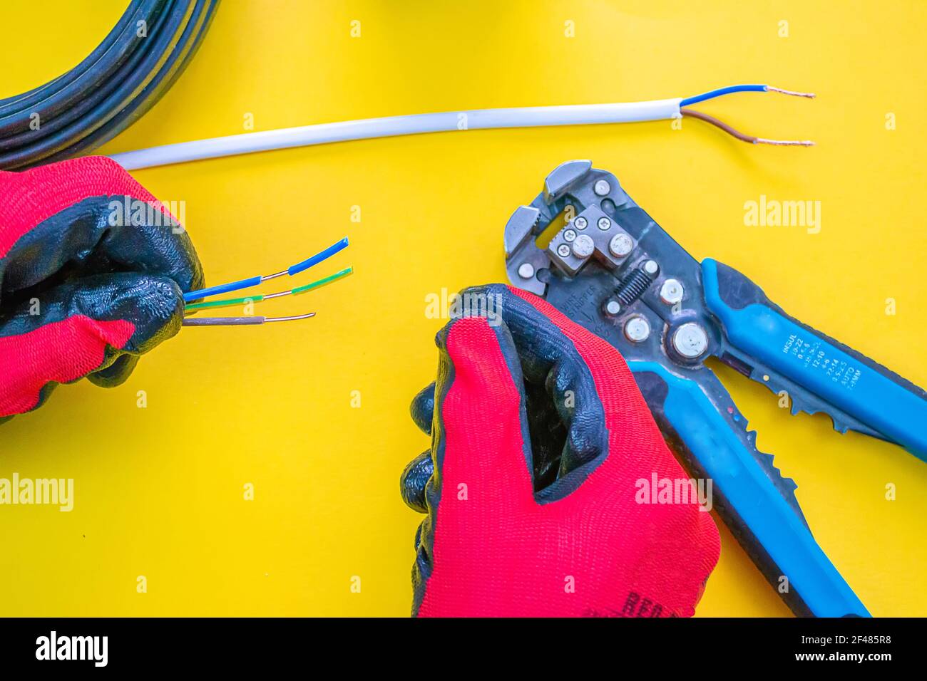 Electrician peeling off insulation from wires - closeup on hands and ...