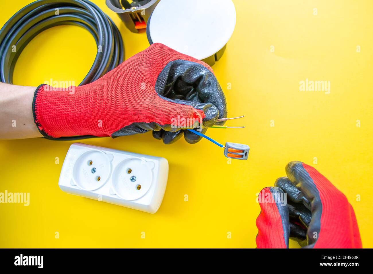 Electrician peeling off insulation from wires - closeup on hands and ...