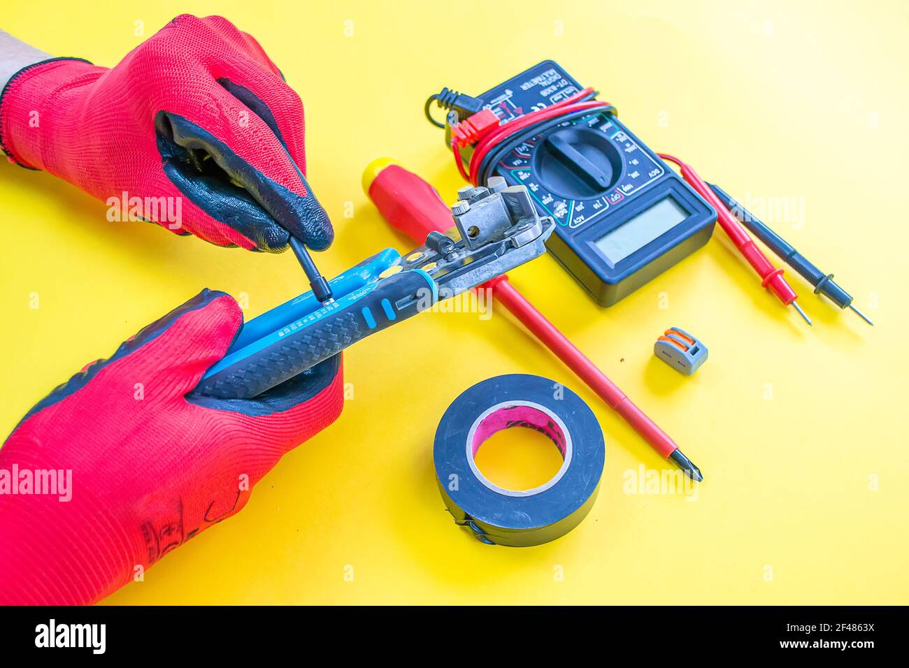 Electrician peeling off insulation from wires - closeup on hands and ...