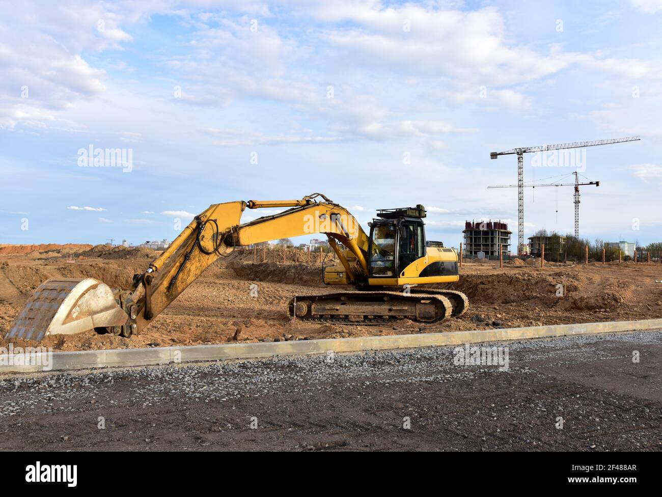Excavator doing earthworks during the construction of a road in a new ...